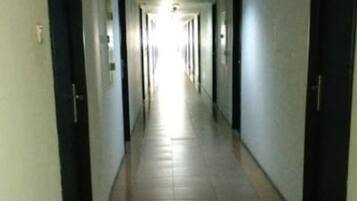 Um corredor comprido e estreito com portas de ambos os lados, que dá acesso a vários quartos.