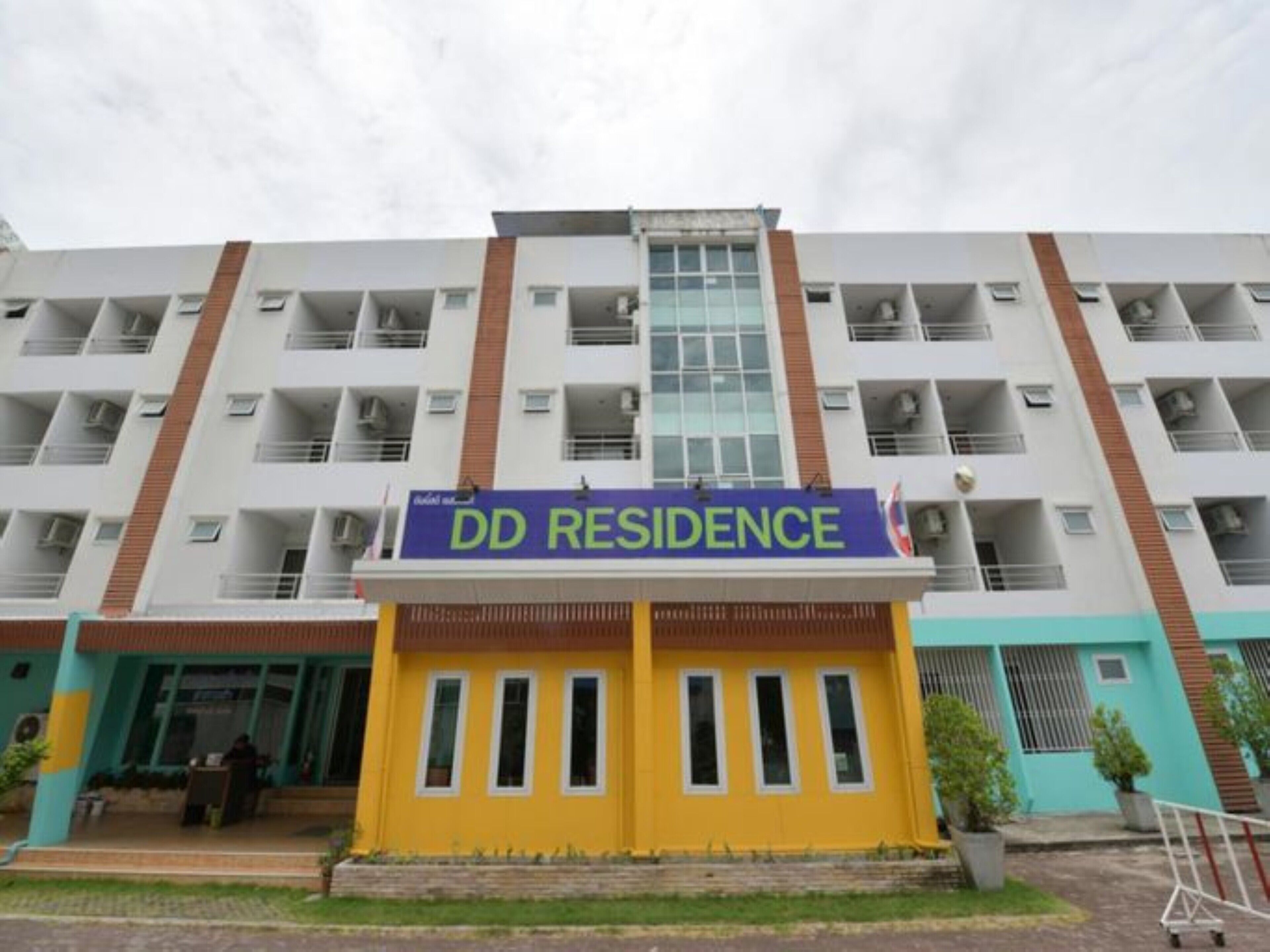 Um edifício de vários andares com uma placa que diz 'DD RESIDENCE'.