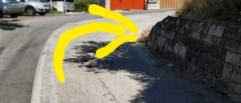 Uma estrada com uma seta amarela indicando uma curva.