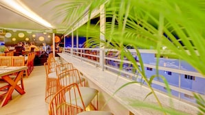 Um restaurante com área externa, vista para a cidade e design de interiores moderno.