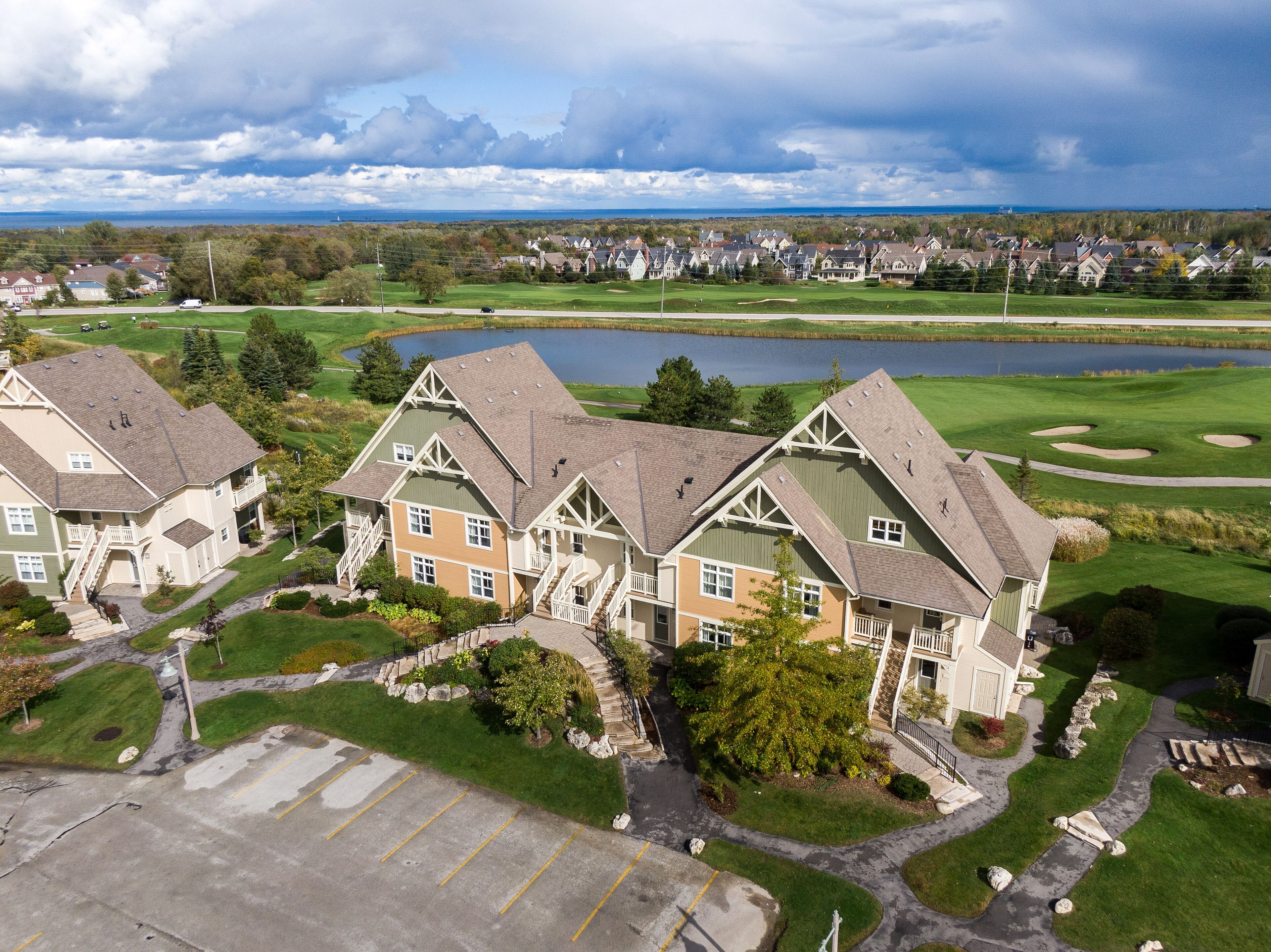 Zona residencial com casas, campo de golfe e um lago.