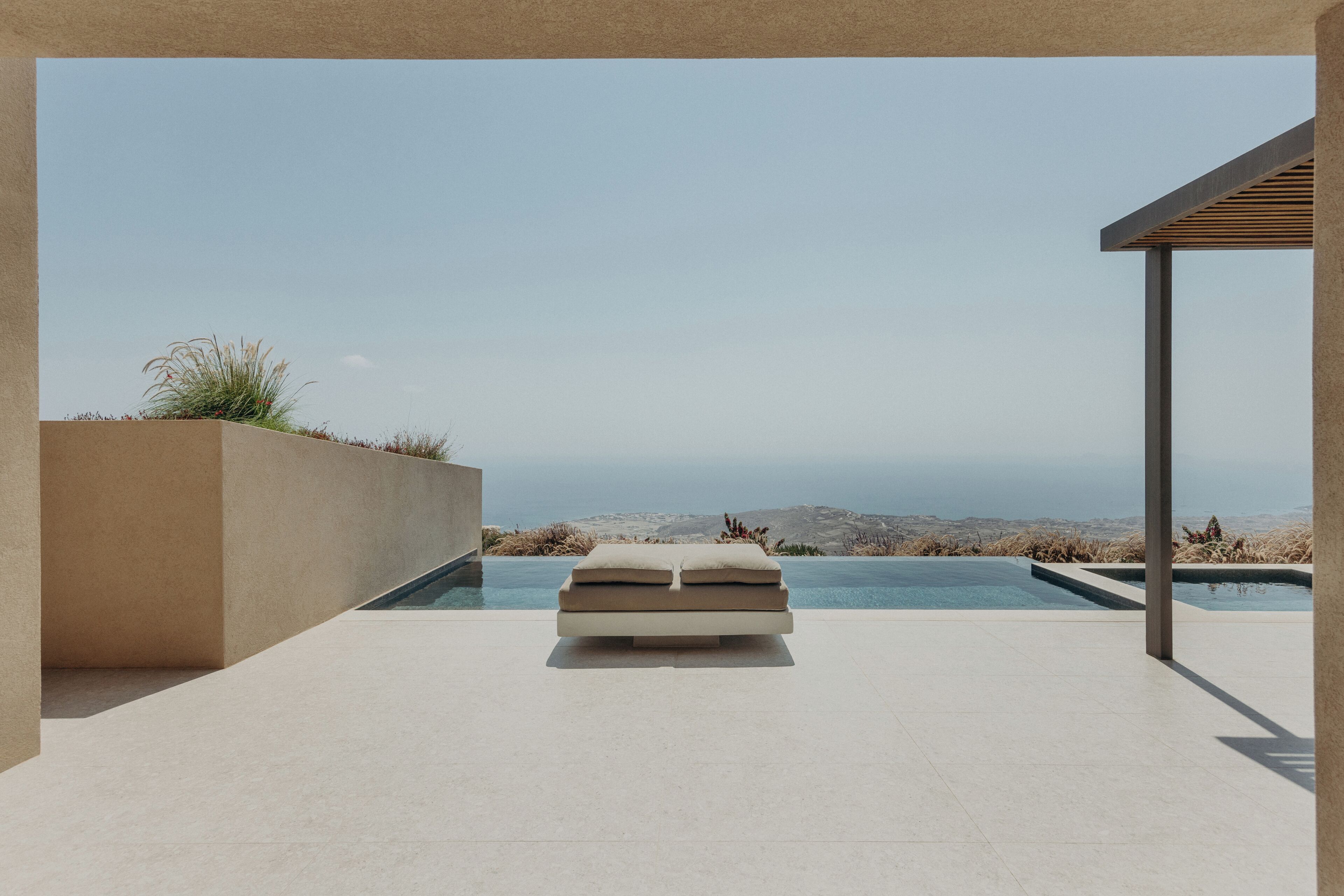 Uma área de piscina moderna ao ar livre, com uma espreguiçadeira minimalista e uma estrutura de pérgola.