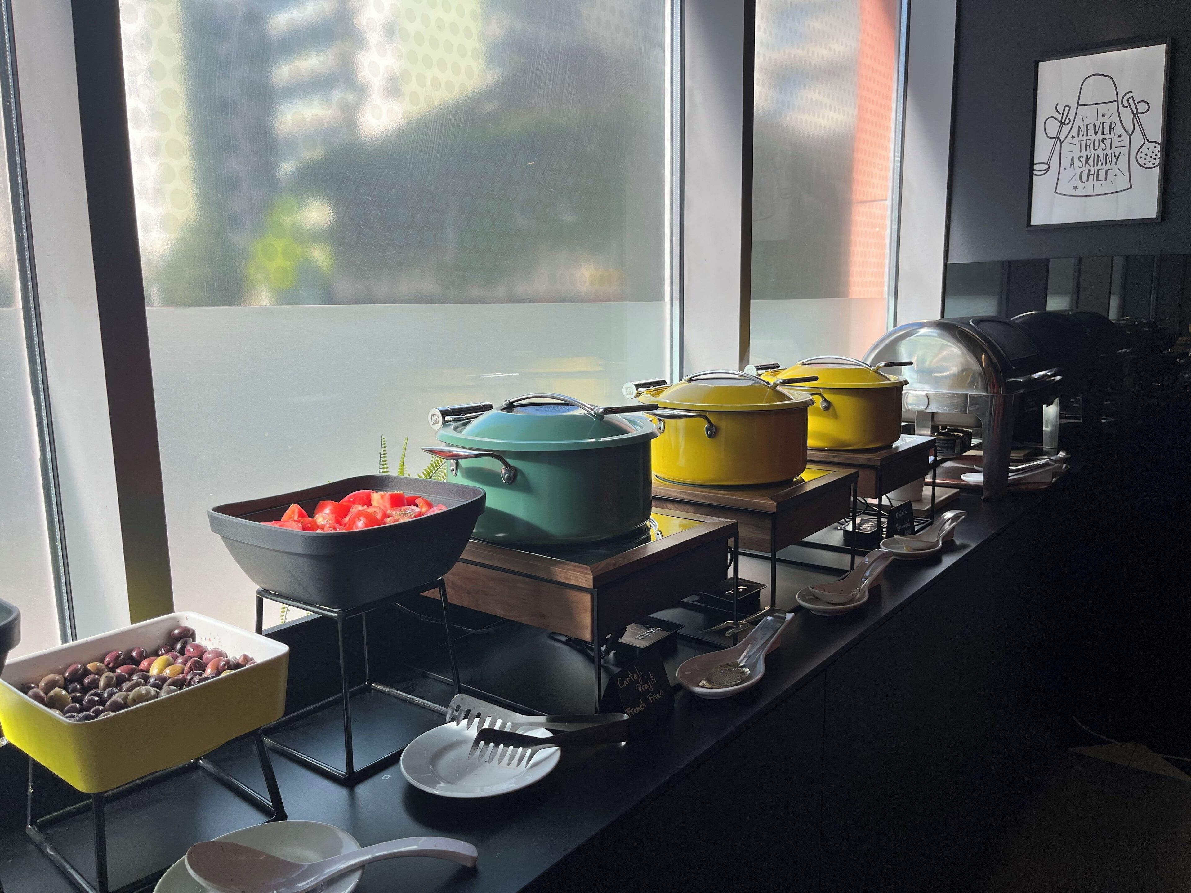 Disposição de buffet com diversos alimentos e utensílios de cozinha.
