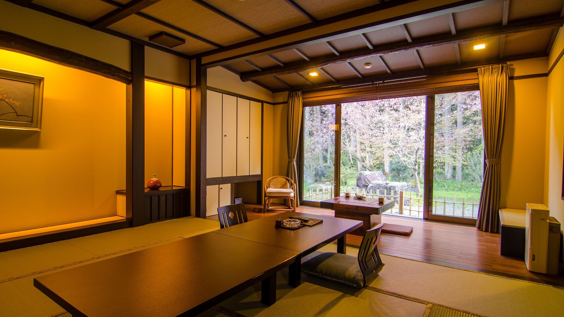 Quarto tradicional japonês com tatames, uma mesa baixa e portas deslizantes.