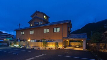 Um edifício japonês tradicional com uma torre imponente, várias janelas e uma entrada coberta.