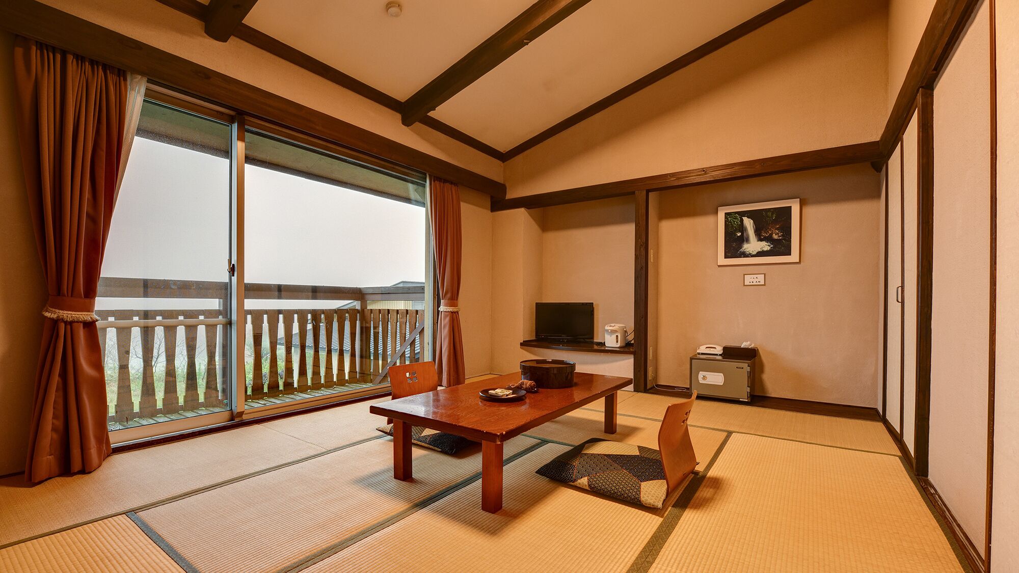 Um quarto japonês tradicional com tatames, uma porta deslizante, uma televisão e um pequeno armário.