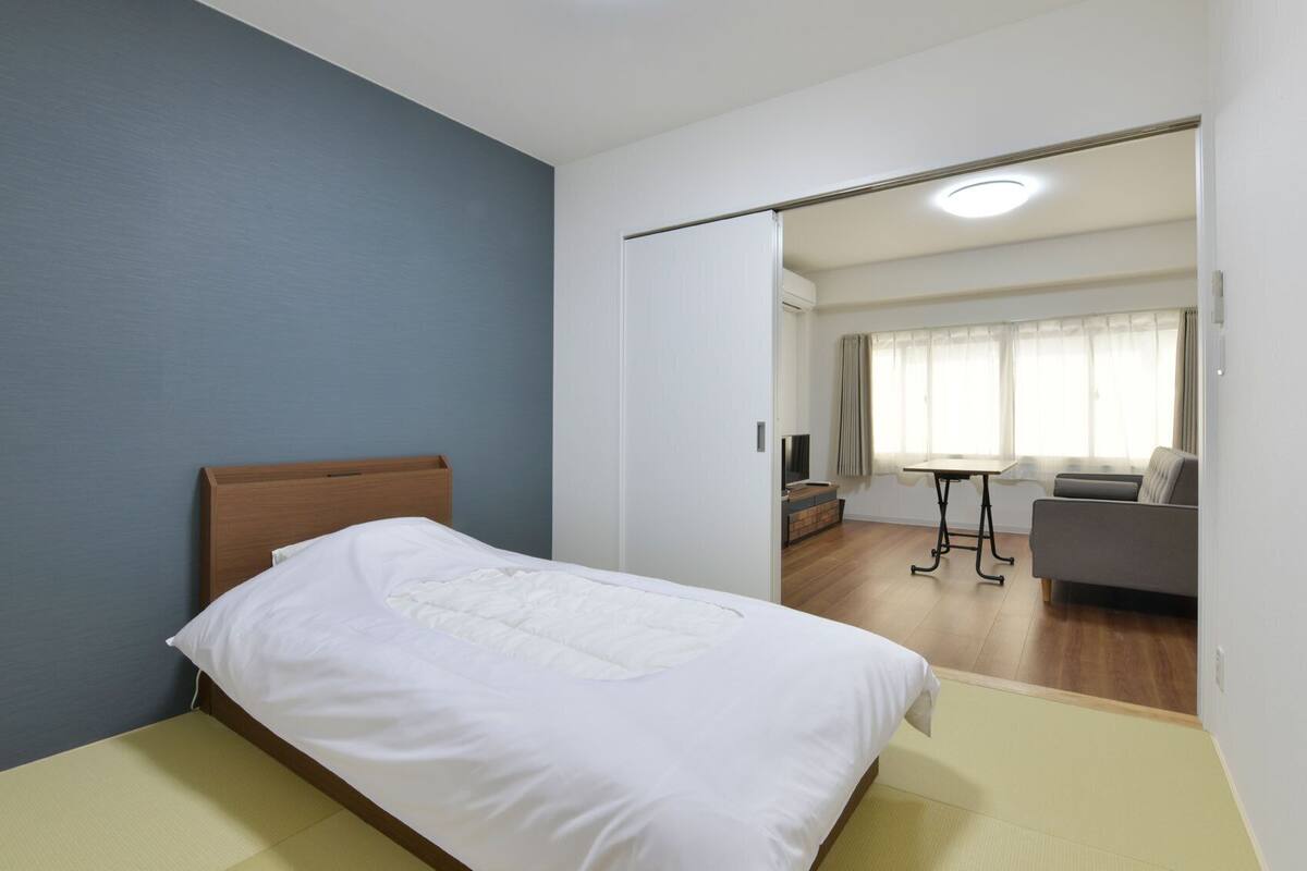 Quarto de hotel com cama, escrivaninha e sofá.