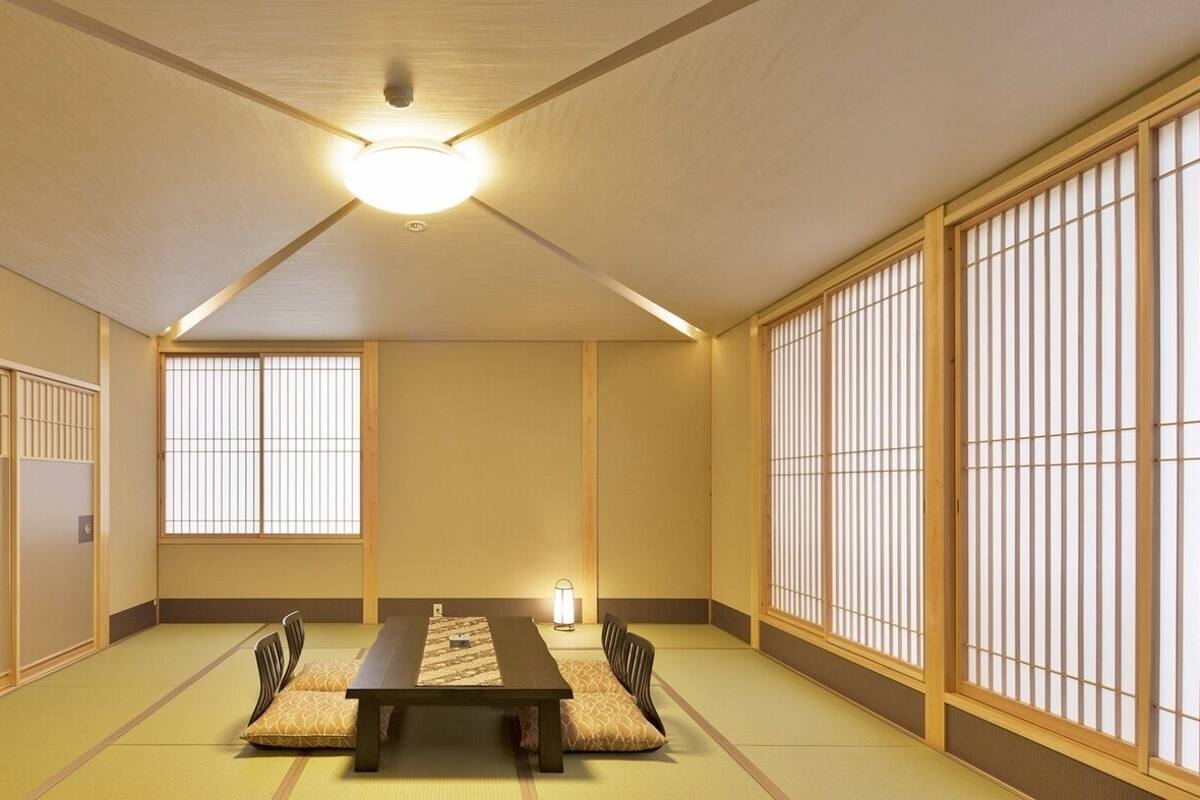 Um quarto japonês tradicional com tatames, uma mesa baixa e portas deslizantes.