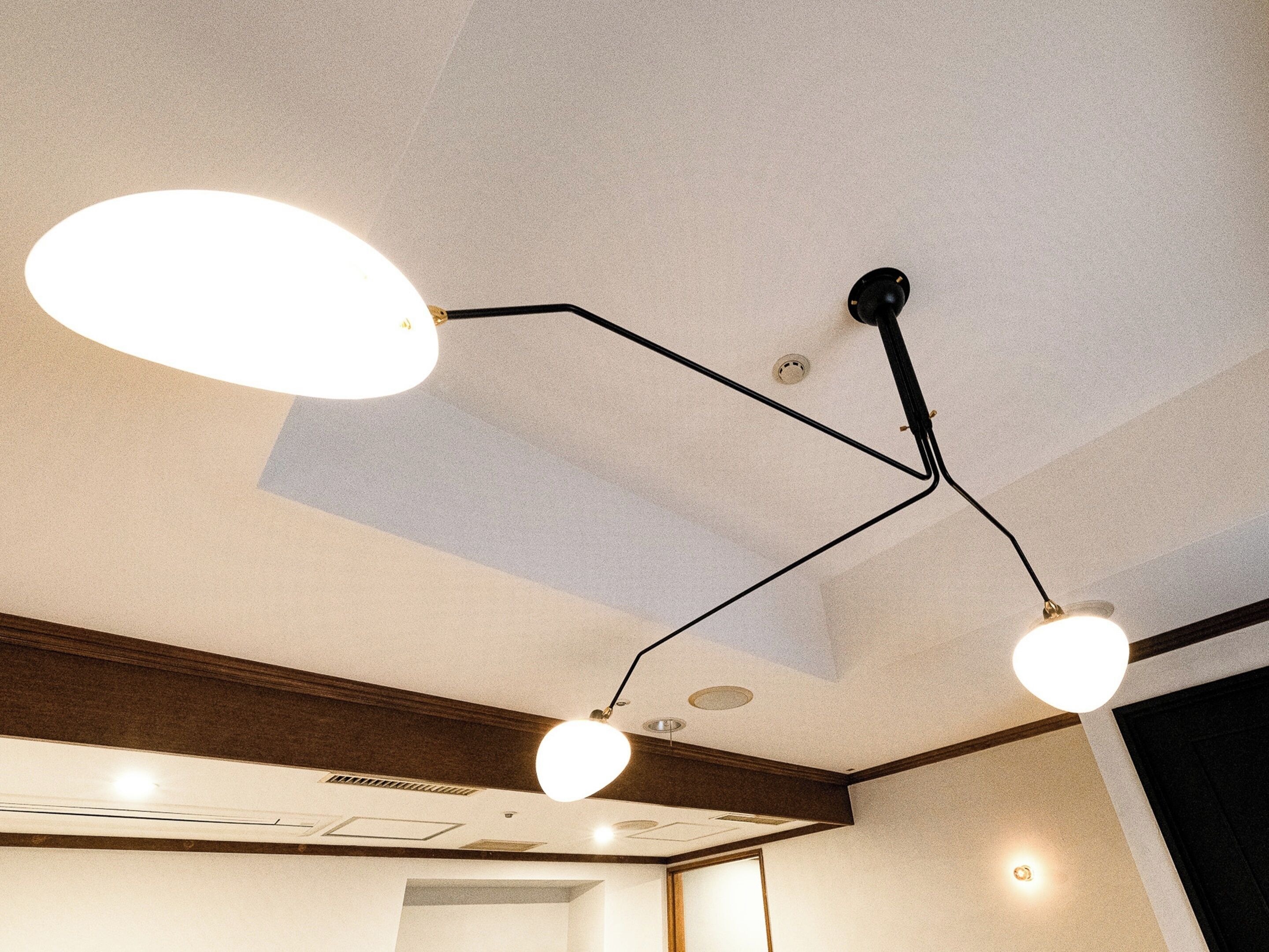 Teto com luminária moderna e três lâmpadas.