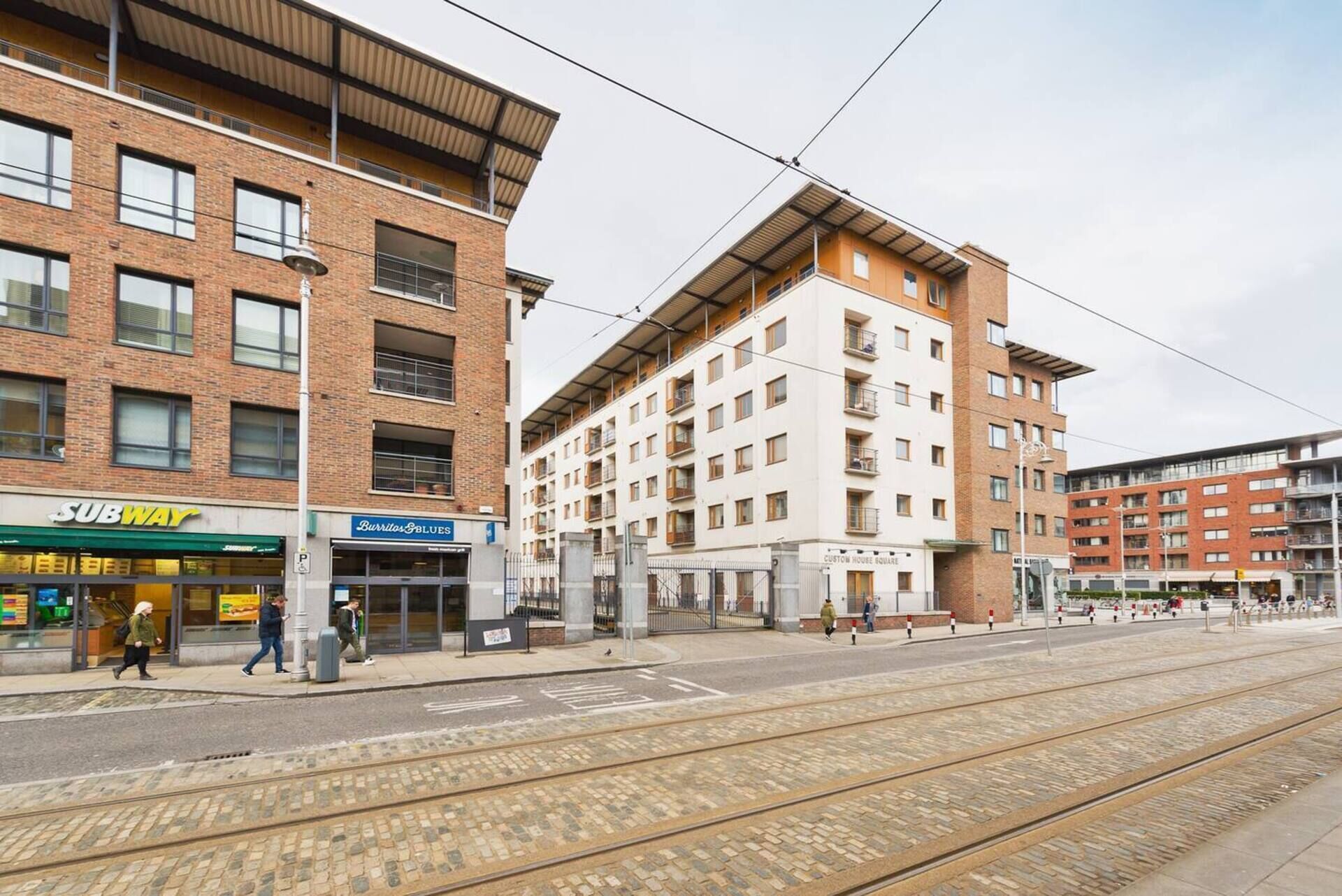 Um edifício de vários andares com um Subway e uma loja Burritos & Lollies no andar térreo.