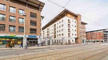 Um edifício de vários andares com um Subway e uma loja Burritos & Lollies no andar térreo.