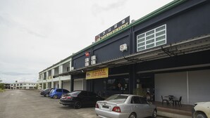 Um edifício com um letreiro anunciando a inauguração. Carros estacionados na frente.