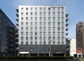 Um edifício moderno de hotel com uma grade de janelas e varandas, chamado Smile Hotel.