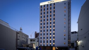 Um prédio alto de hotel com uma placa no topo que diz "SUPERHOTEL".