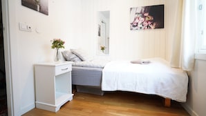 Quarto com cama, mesa de cabeceira, penteadeira e espelho.