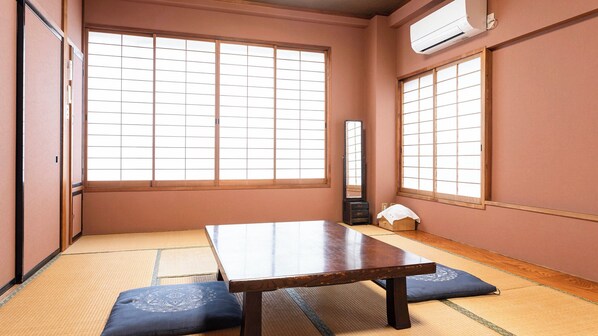 Um quarto japonês tradicional, com tatames, uma mesa baixa e portas deslizantes.