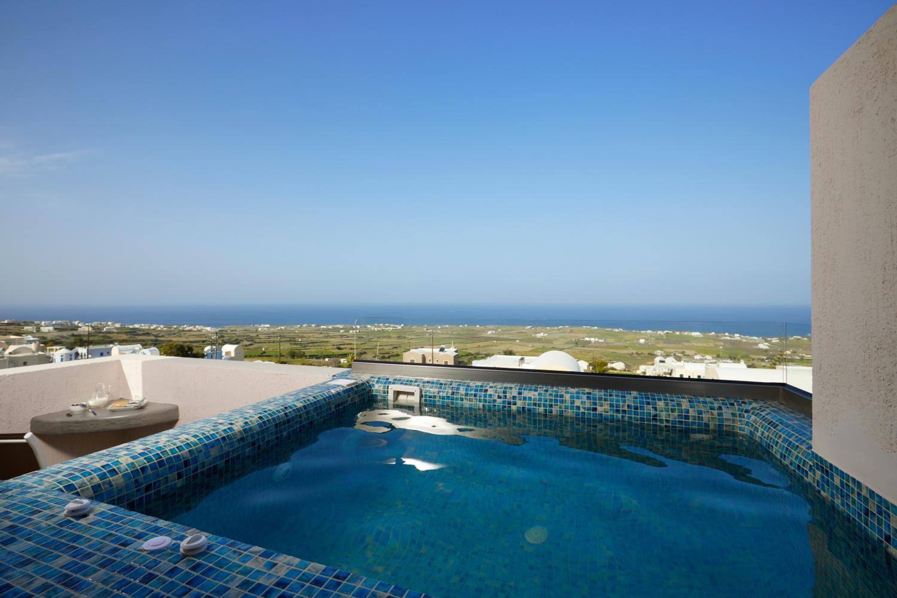 Piscina infinita no terraço com vista clara para o oceano e paisagem distante.