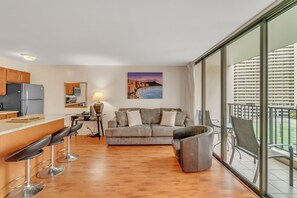 Um apartamento moderno com cozinha, sala de jantar e varanda com vista para a cidade.