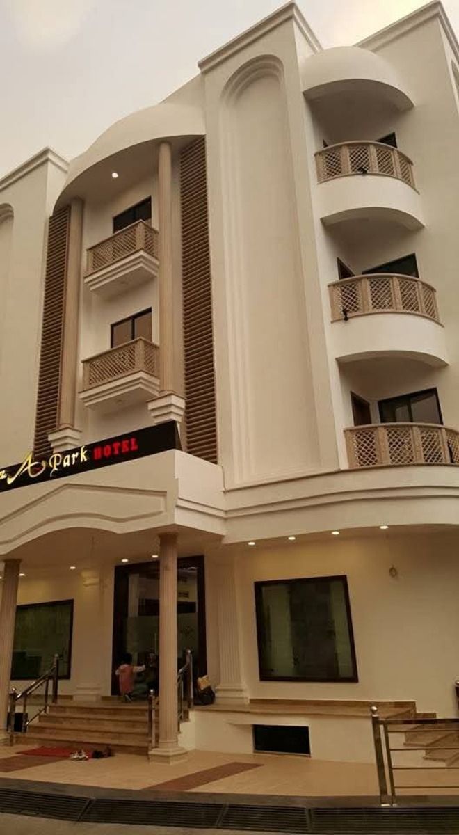 Um hotel com vários andares, entrada imponente, varandas e uma placa com a inscrição "Park Hotel".