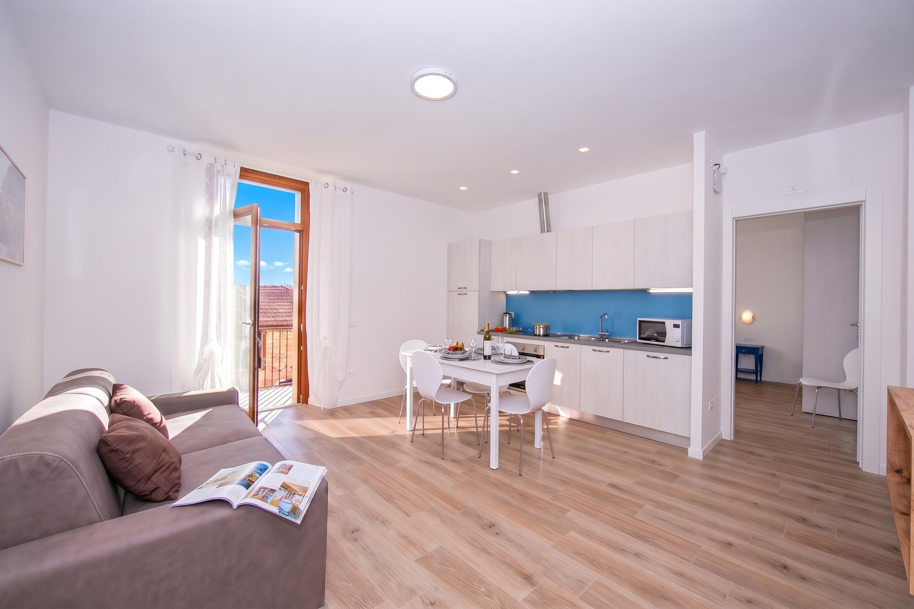 Uma sala moderna com sofá e área de jantar com mesa e cadeiras.