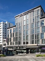 Um edifício de hotel moderno com uma placa em destaque que diz "Mercure Hotel".