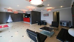Um saguão de hotel moderno com balcão de recepção, área de estar e um pinheiro de Natal.