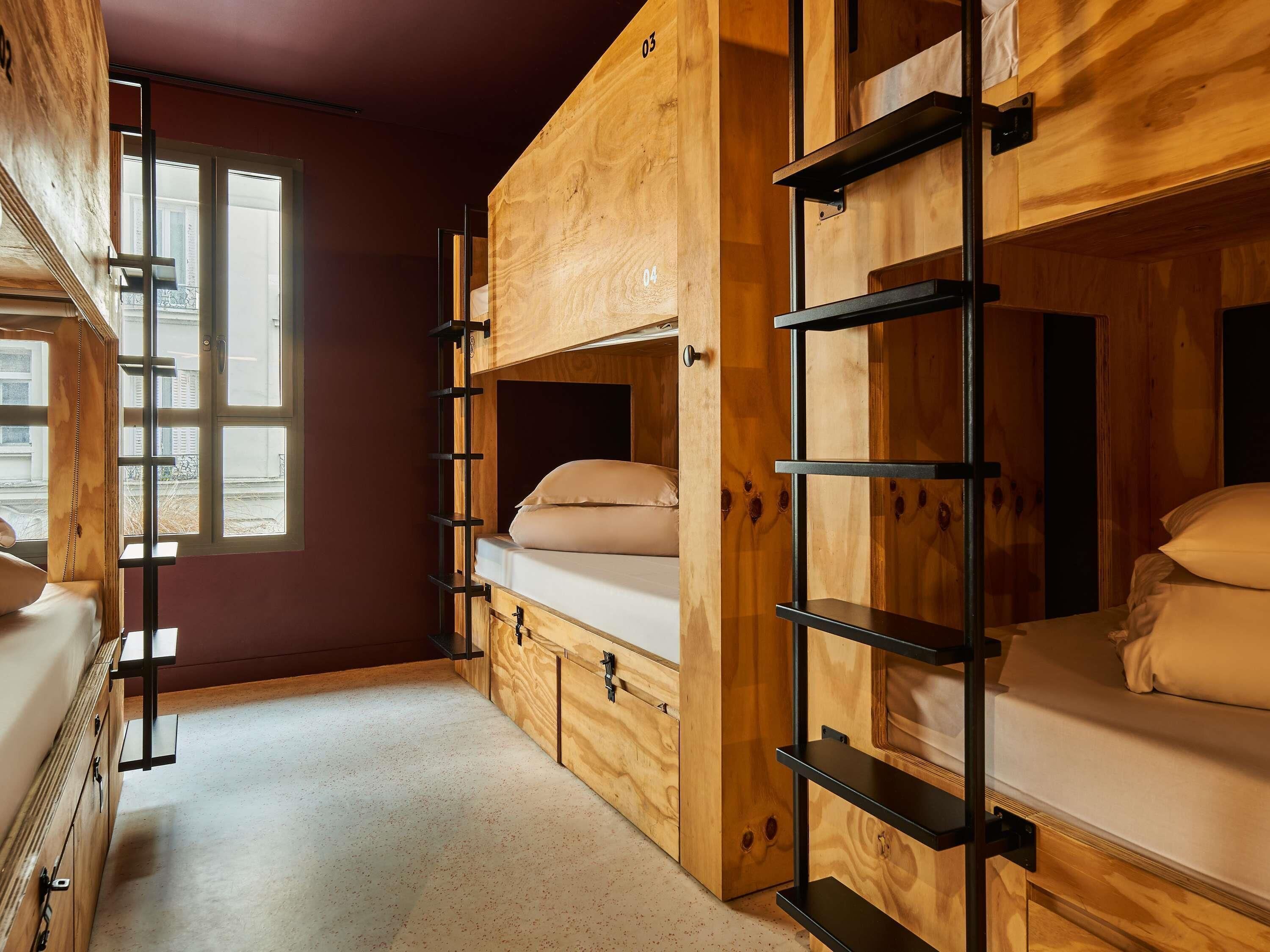 Quarto com beliches, guarda-roupa de madeira e janela.