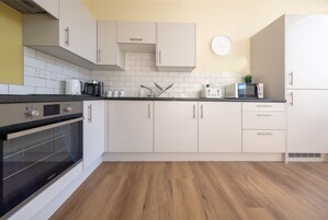 Apartamento empresarial | Cozinha privada | Geladeira grande, micro-ondas, fogão, cooktop