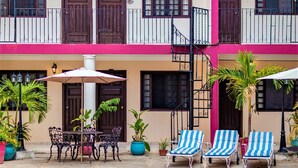Hotel com piscina, área de estar ao ar livre e um edifício de dois andares com varandas.