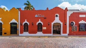Um edifício vermelho com uma placa que diz 'Hotel San Juan'.