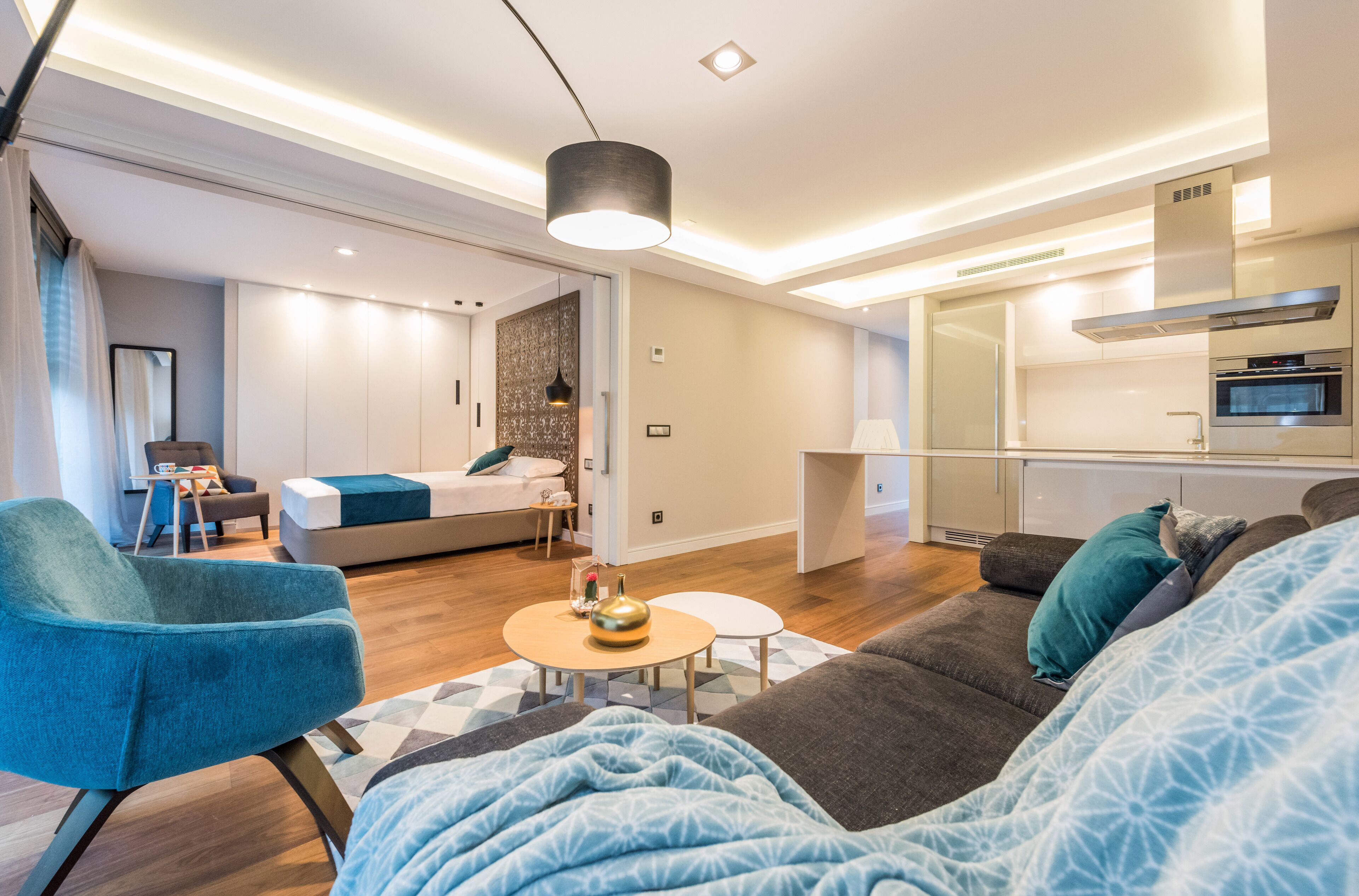 Uma sala de estar moderna com sofá, poltrona e uma mesa redonda pequena com um objeto decorativo.