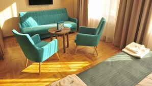 Uma sala de estar com um sofá verde-azulado, duas poltronas combinando, uma pequena mesa de madeira e um tapete de exercícios verde.