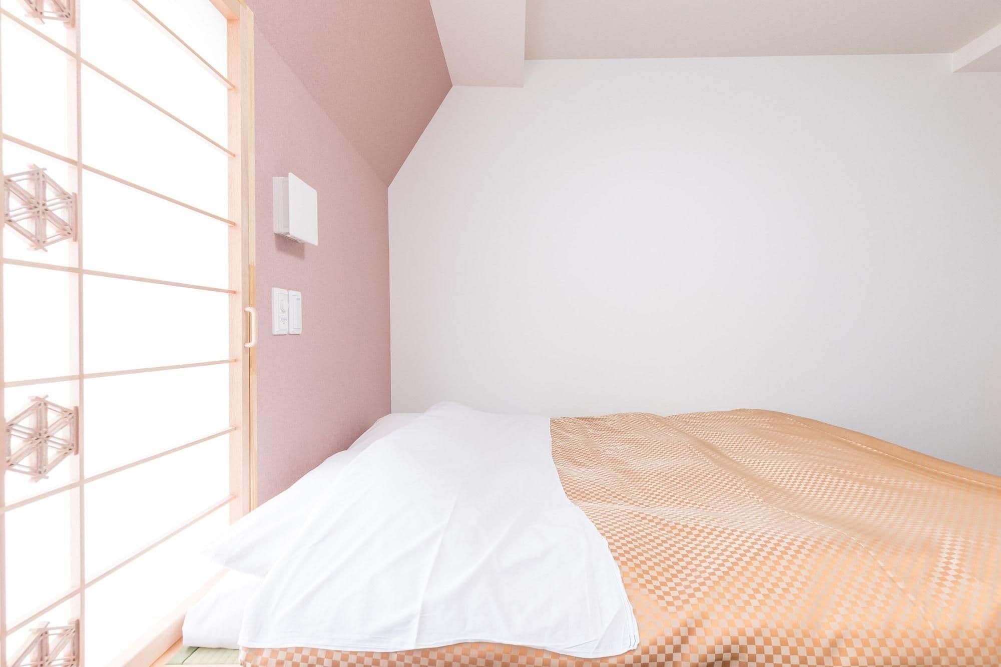 Quarto com cama, janela com padrão quadriculado e ar-condicionado fixado na parede.