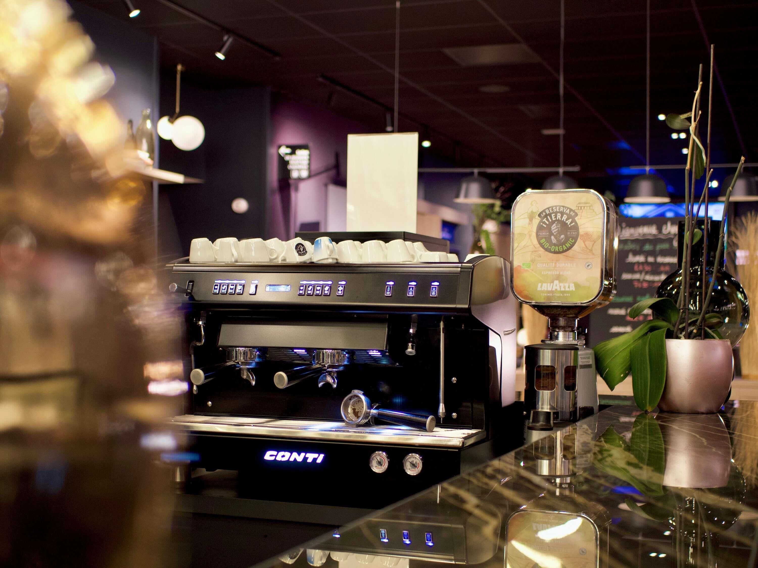 Máquina de café com visor digital e torneira para café.
