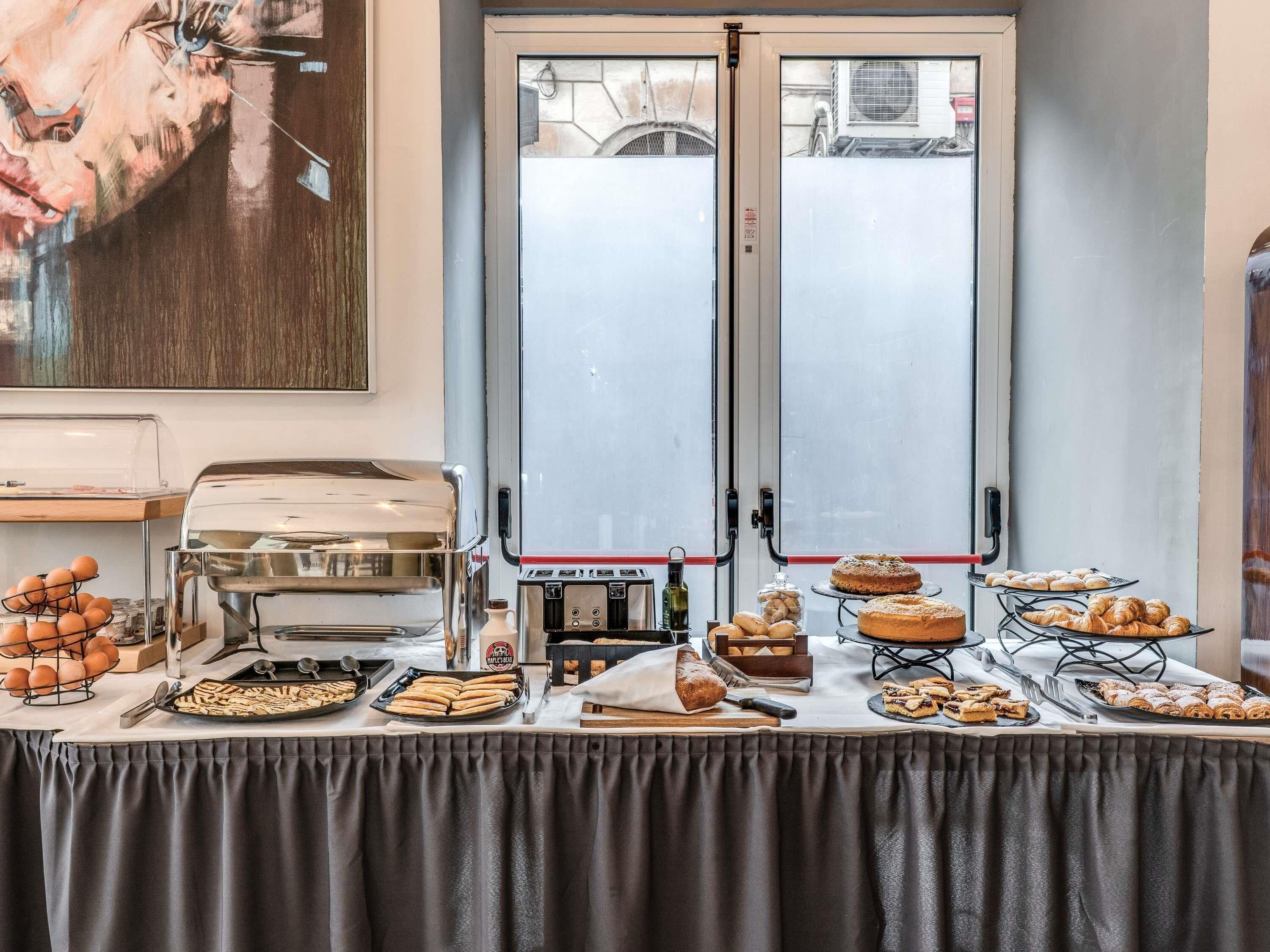 Um buffet de café da manhã com diversos pães, bolos e ovos.