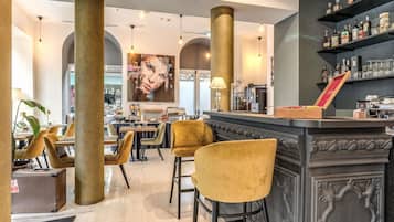 Uma área de bar com balcão, banquetas e prateleiras cheias de garrafas.