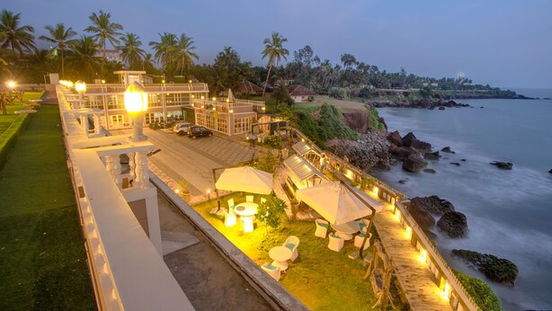 Um resort à beira-mar com área externa para sentar, piscina e vista para o oceano.