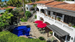 Um resort com piscina, área de estar ao ar livre e um espaço coberto com varanda.