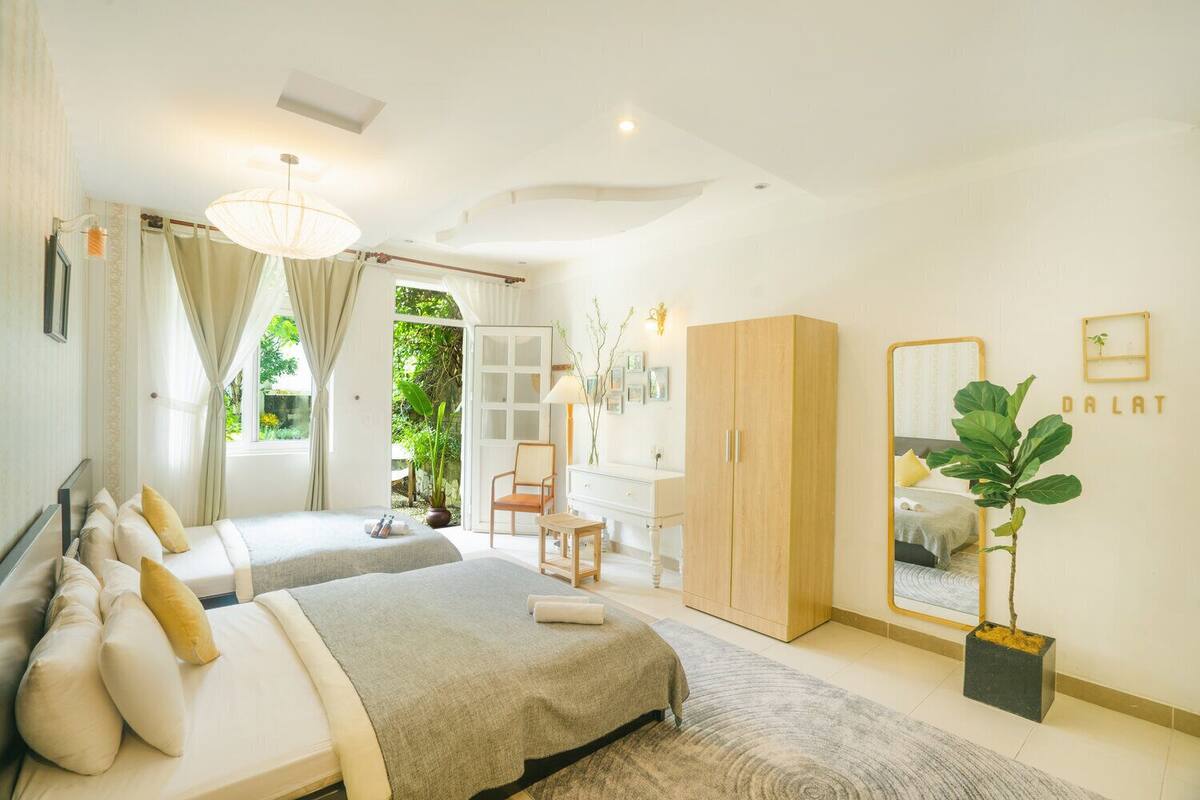 Quarto com cama, cadeira, guarda-roupa, espelho e planta em vaso.