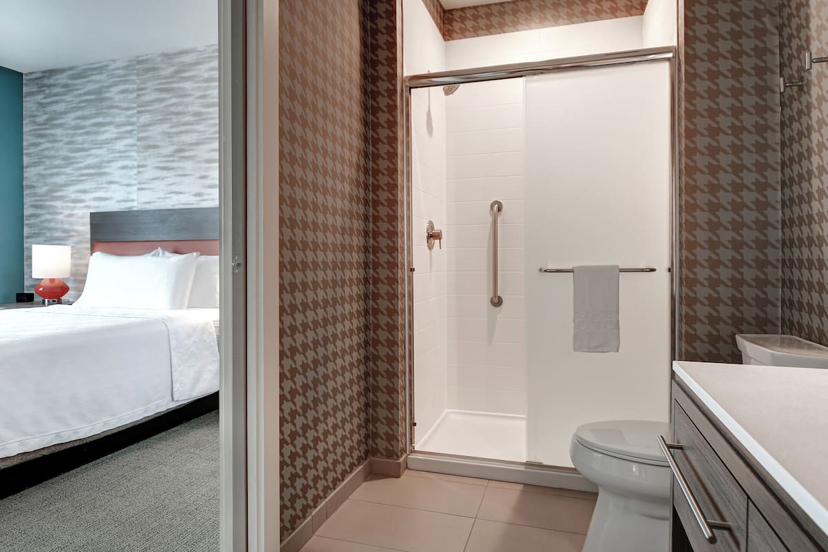 Um secador de cabelo, toalhas fornecidas, sabão, champô