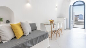 Uma sala de estar moderna com um sofá, uma mesa de jantar e cadeiras.