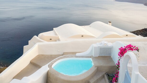 Uma piscina infinita branca com vista para o mar, uma piscina infinita branca e outra piscina infinita branca.