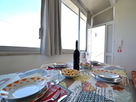 Mesa posta com pratos, copos, garrafa e comida.