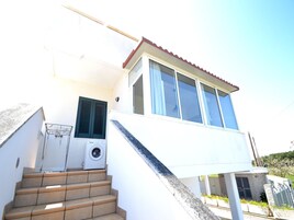 Um edifício residencial com escadas, máquina de lavar e janela com cortina.