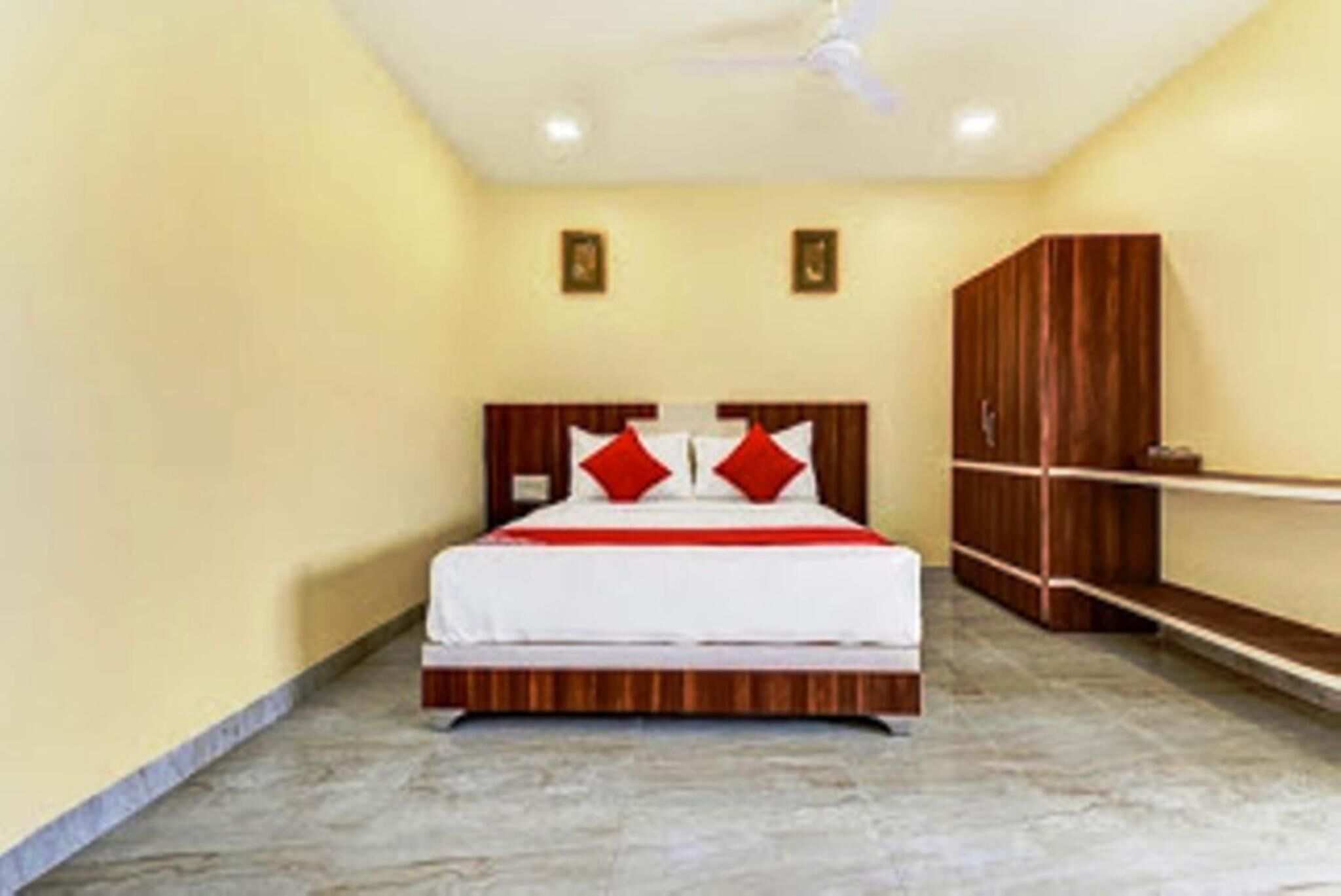 Quarto com cama, guarda-roupa e ventoinha no teto.