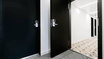 Um corredor com portas pretas, piso estampado e design de interiores moderno.