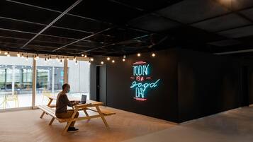 Decoração moderna com um letreiro de neon, bancos de madeira e uma janela grande.