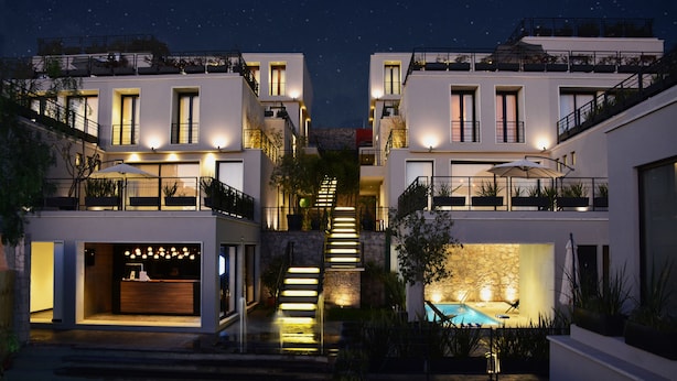 Um edifício moderno com piscina, área de estar externa e escadaria que leva aos andares superiores.