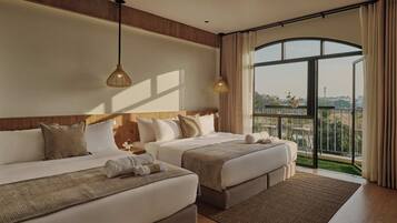 Quarto de hotel com duas camas, uma janela grande e vista, e teto de madeira.