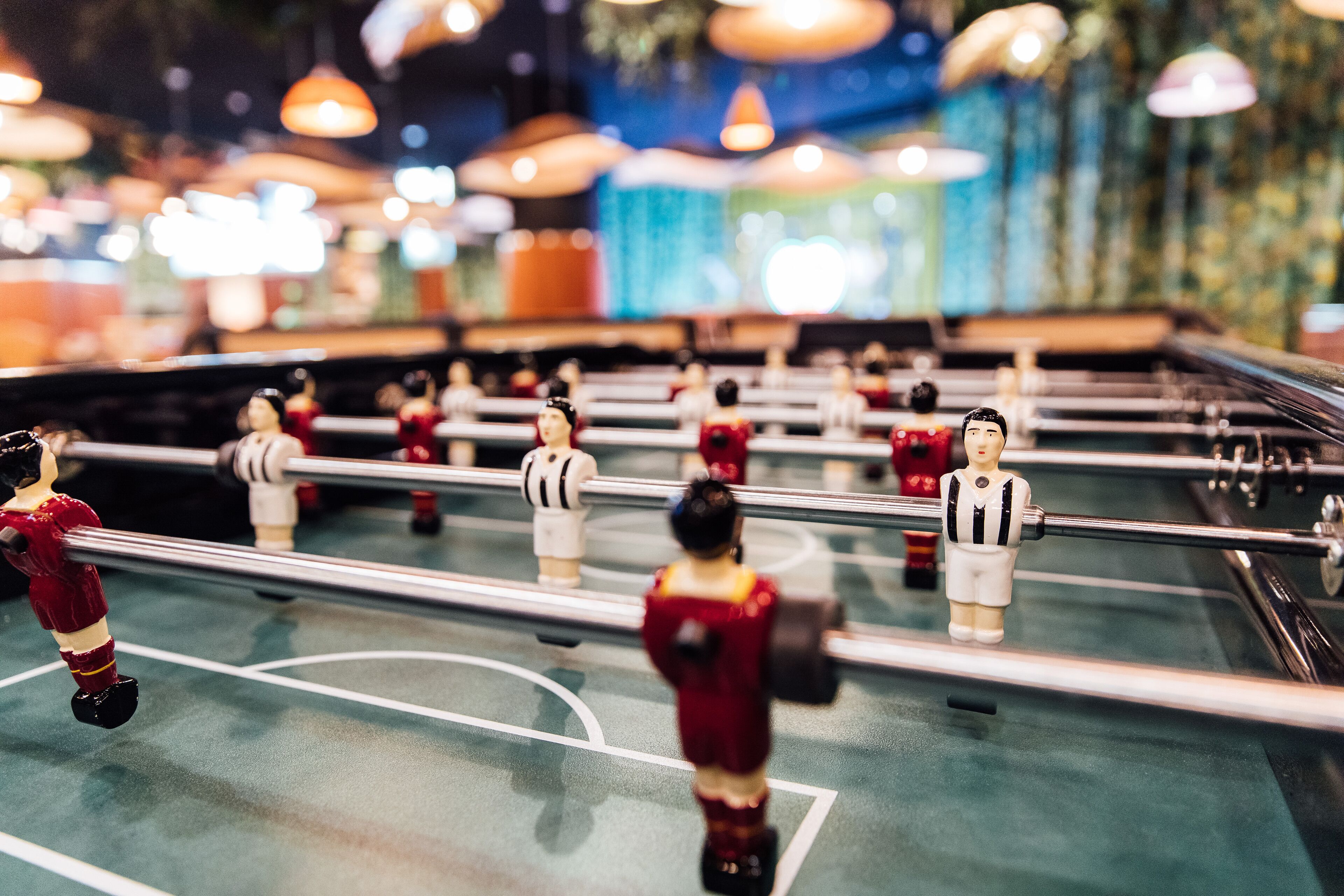 Uma mesa de futebol de mesa com jogadores de uniformes vermelhos e brancos.